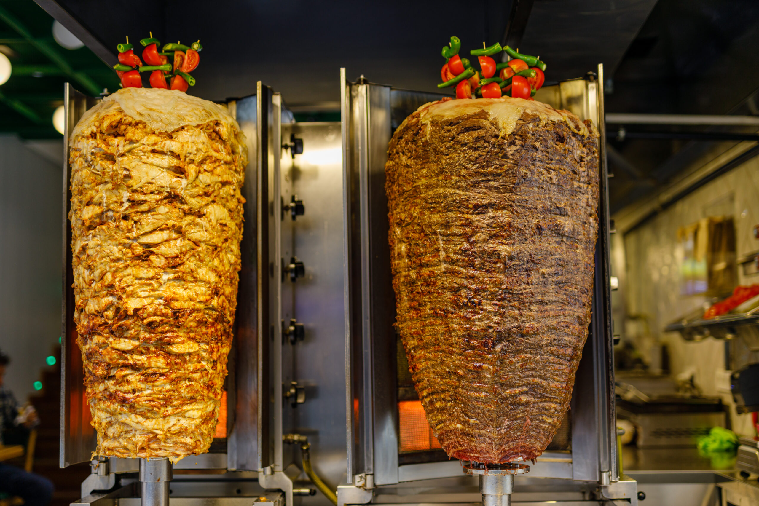 Grilled chicken meat on a vertical rotisserie used in traditional ...